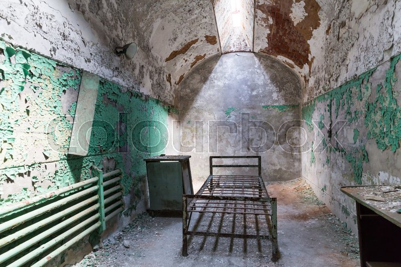Grunge prison cell with metal bed and ... | Stock Photo | Colourbox