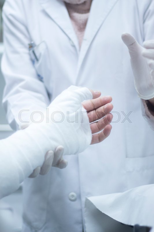 Doctor applying a plaster cast and ... | Stock image | Colourbox