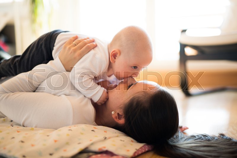 Beautiful mother lying on the floor, ... | Stock image | Colourbox
