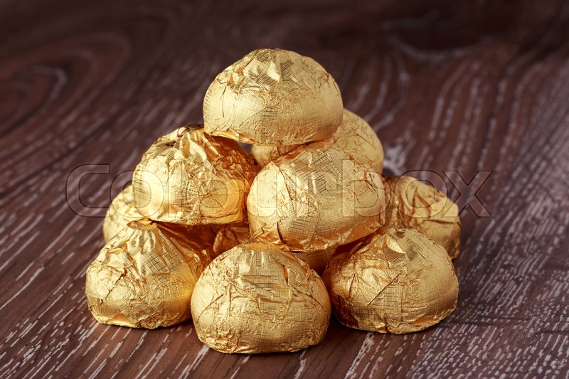 Candy in gold wrapper on the wooden ... | Stock image | Colourbox