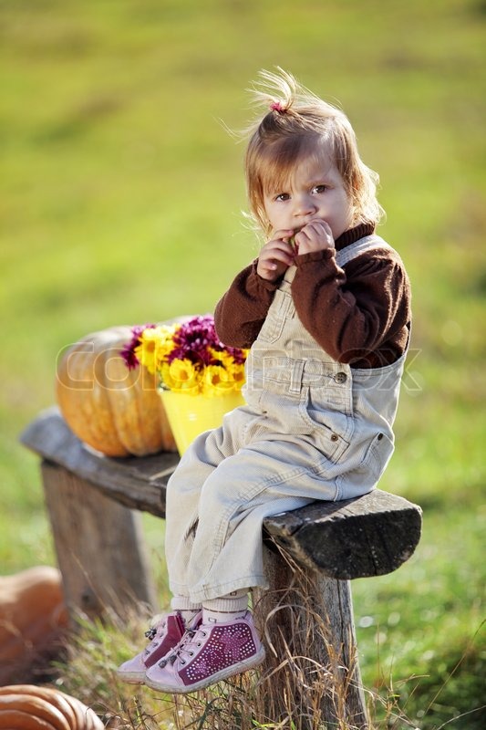 Cute child sitting on bench near ... | Stock image | Colourbox