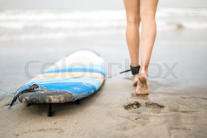 Female legs with a colorful surfboard ... | Stock image | Colourbox