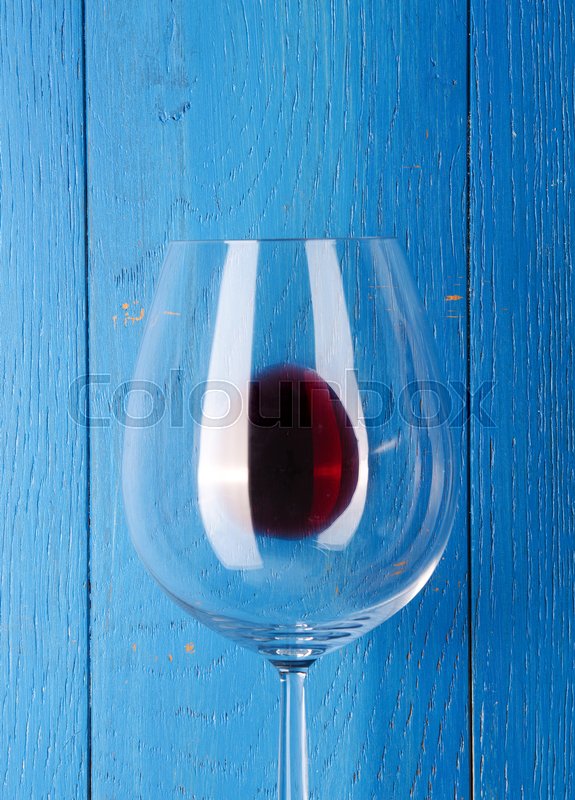 Glass of red wine on a blue rustic ... | Stock image | Colourbox