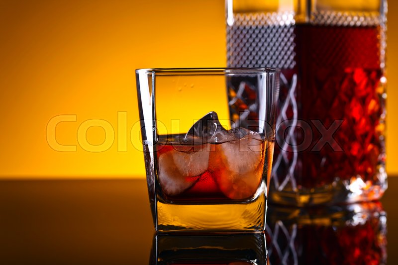 Whiskey with ice on a reflective ... | Stock image | Colourbox