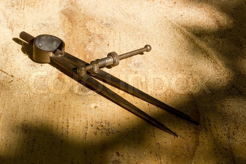 A metal drafting compass on a wooden ... | Stock image | Colourbox
