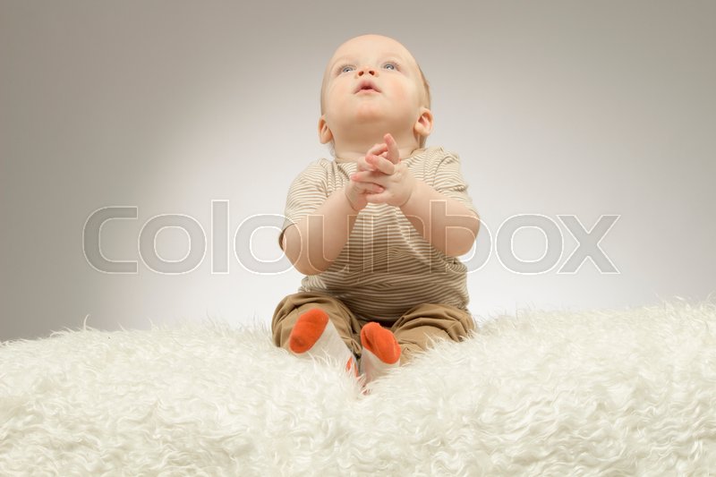 Adorable little baby sitting on the ... | Stock image | Colourbox