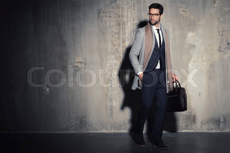 Businessman in suit standing in shadowy ... | Stock Photo | Colourbox