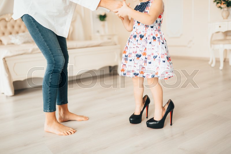 A little girl in her mother's shoes. A ... | Stock image | Colourbox