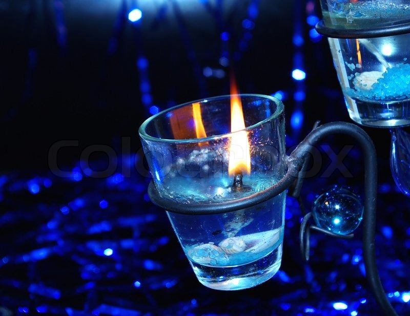 Blue lighting candle in candlestick | Stock image | Colourbox