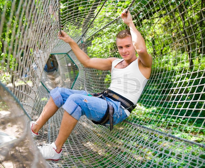 Strong young men in a rope park on the ... | Stock image | Colourbox