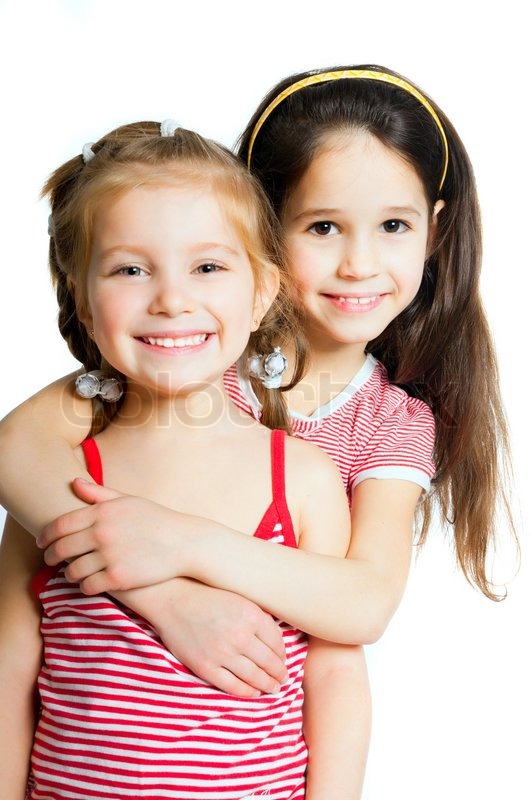 Two beautiful little girls on a white ... | Stock image | Colourbox