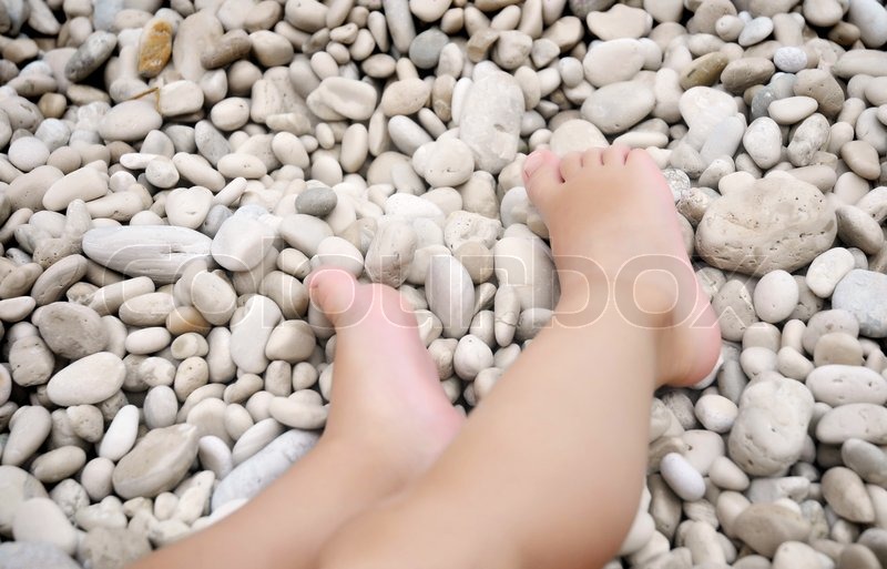 Children's feet and white pebbles on ... | Stock image | Colourbox