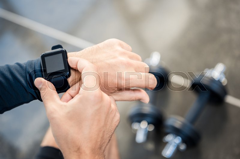 Handsome young man using smartwatch at ... | Stock image | Colourbox