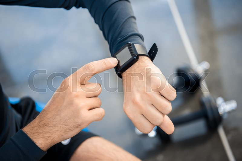 Handsome young man using smartwatch at ... | Stock image | Colourbox