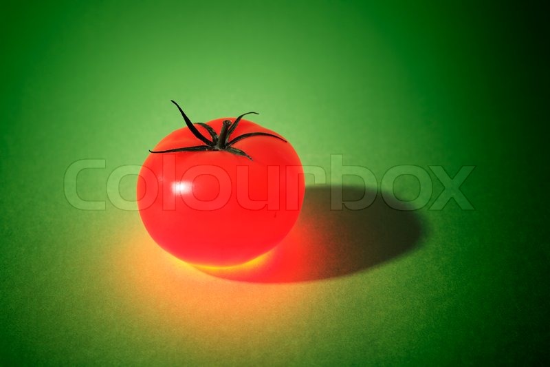 A Glowing Tomato on green background ... | Stock image | Colourbox