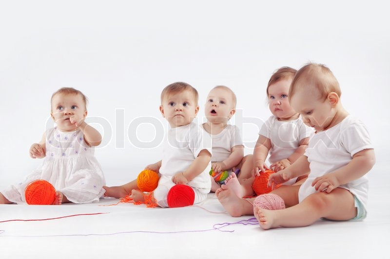 Group of babies sitting on white studio ... | Stock image | Colourbox