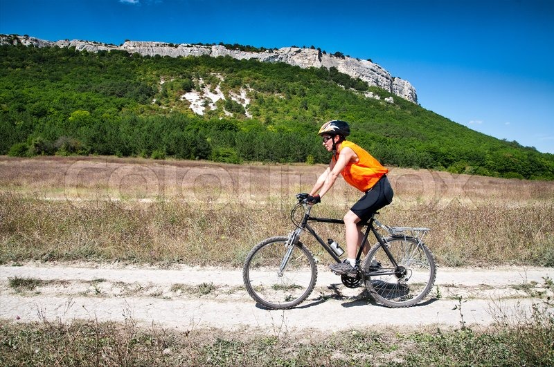 Young athletic girl rides a bicycle on ... | Stock image | Colourbox