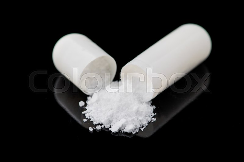 Open white capsule with powder on ... | Stock image | Colourbox