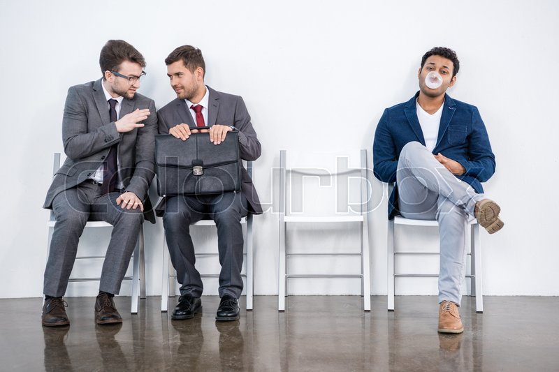 Businessmen in suits sit on chairs at ... | Stock image | Colourbox