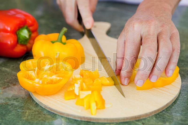 Woman chopping peppers on chopping ... | Stock image | Colourbox