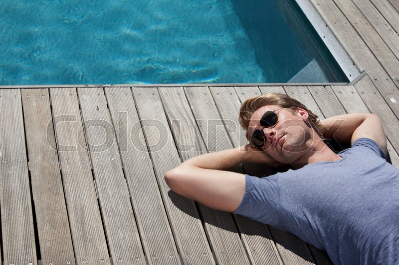 Man relaxing by swimming pool | Stock image | Colourbox
