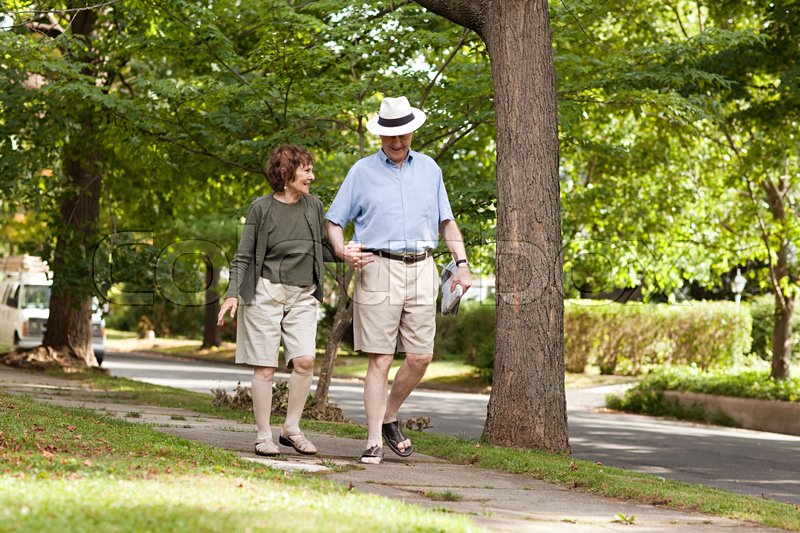 Senior couple walking in neighborhood | Stock image | Colourbox