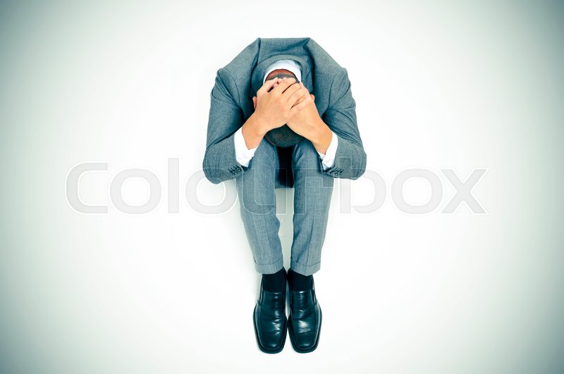 A businessman curled up in the floor ... | Stock image | Colourbox