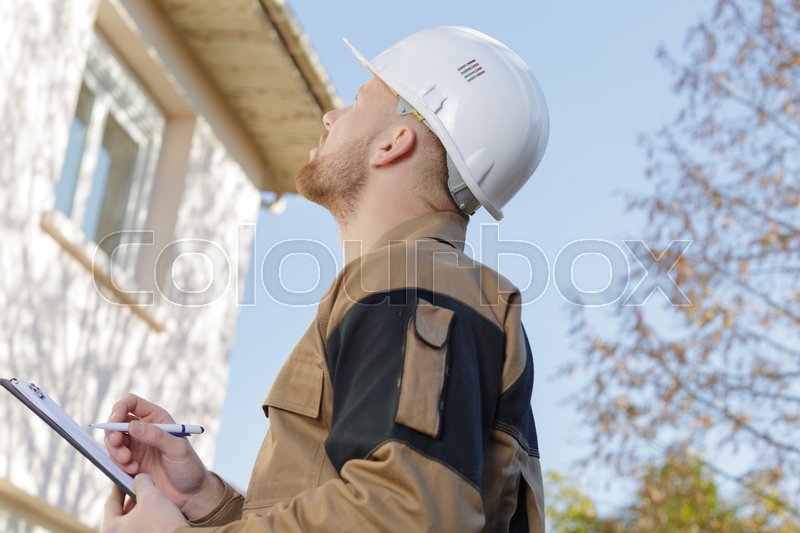 Male contractor looking up while ... | Stock image | Colourbox