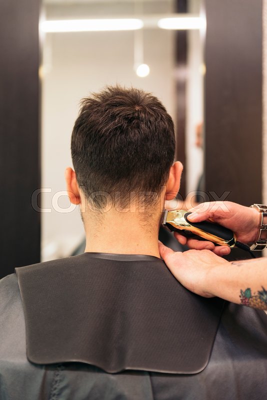 Hairstylist making men's haircut to an ... | Stock image | Colourbox