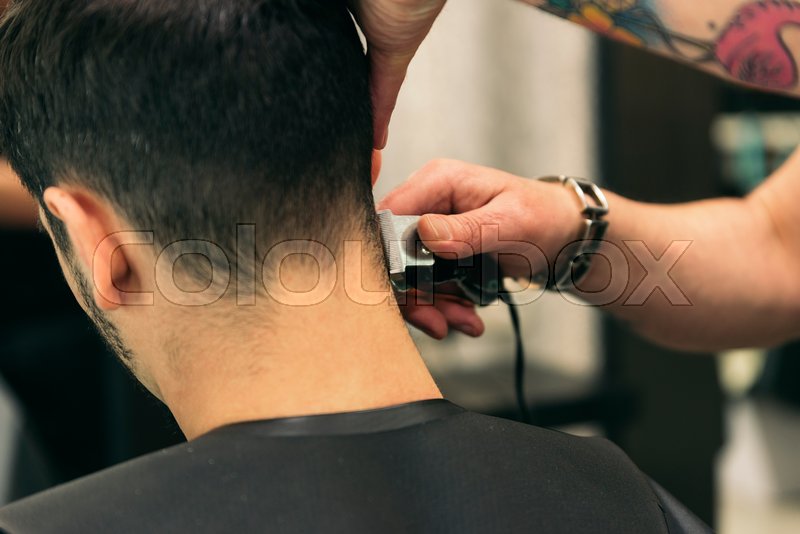 Hairstylist making men's haircut to an ... | Stock image | Colourbox