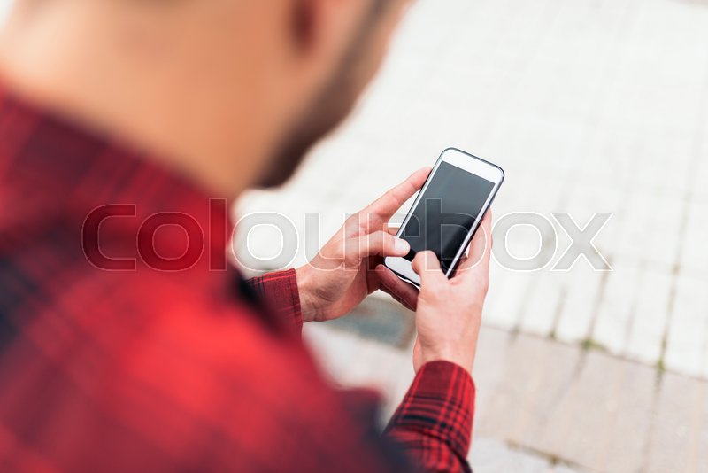 Young man using his mobile in the ... | Stock image | Colourbox
