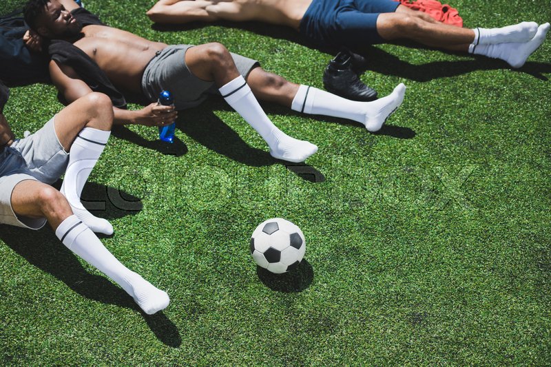 Soccer players resting on football ... | Stock image | Colourbox
