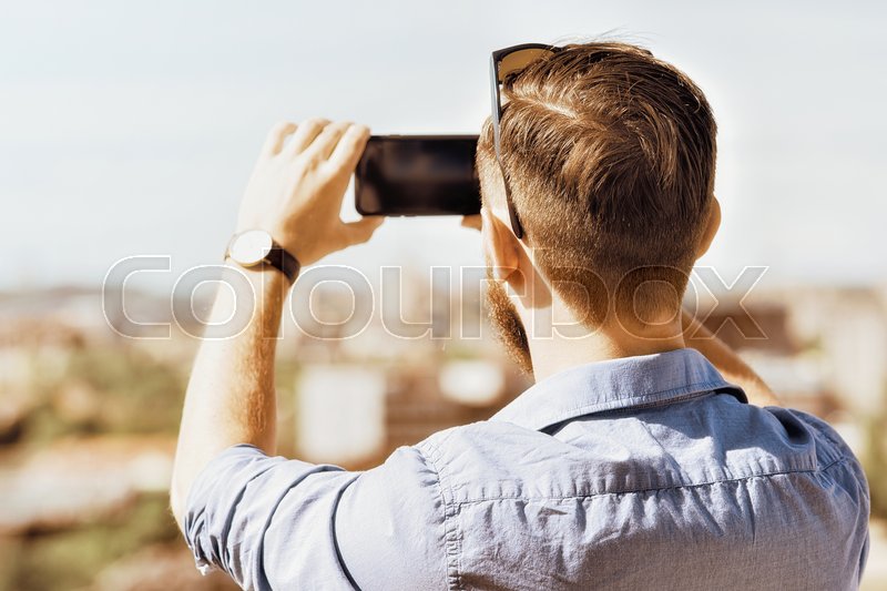 Young caucasian man taking photos on ... | Stock Photo | Colourbox