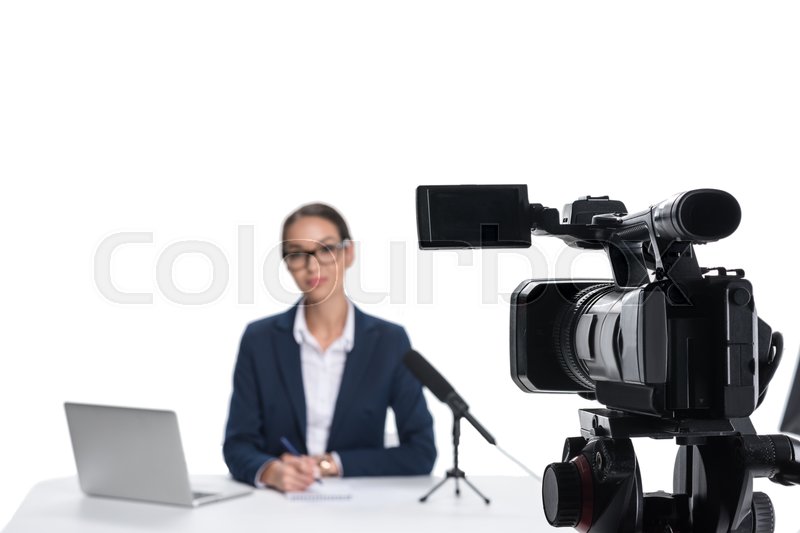 Female newscaster sitting at table with ... | Stock image | Colourbox