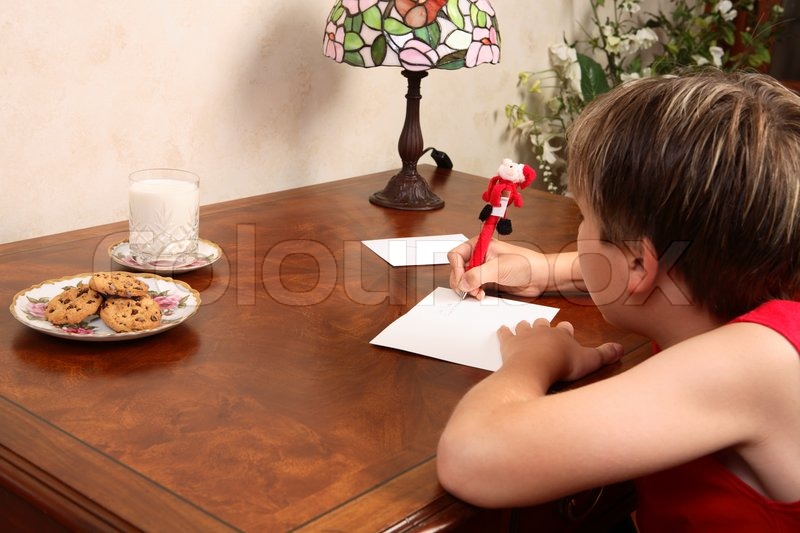 A child sitting at a desk writing a ... | Stock image | Colourbox