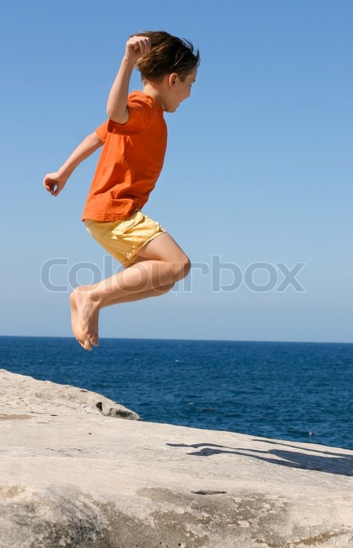 An energetic little boy jumps high into ... | Stock image | Colourbox