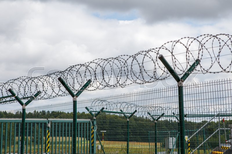 Security fence with a barbed wire. ... | Stock image | Colourbox