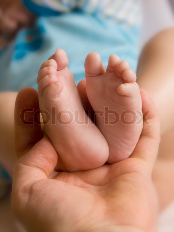 Soft holding her child's little feet | Stock Photo | Colourbox