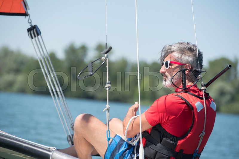 Young man skipper at his sail boat | Stock image | Colourbox