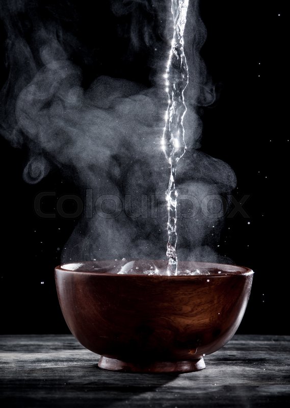 Pouring hot water into into a bowl on a ... | Stock image | Colourbox