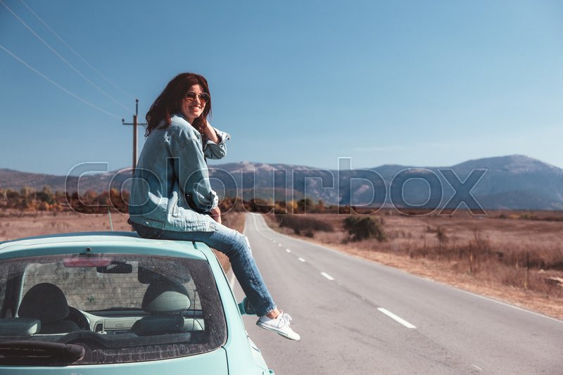 Hipster girl relaxing on the car roof ... | Stock image | Colourbox