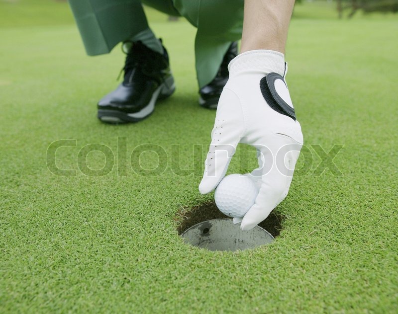Hand nimmt einen Golfball aus dem Loch | Stock Bild | Colourbox