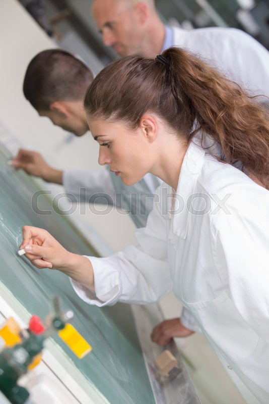 Students writing on the board | Stock image | Colourbox