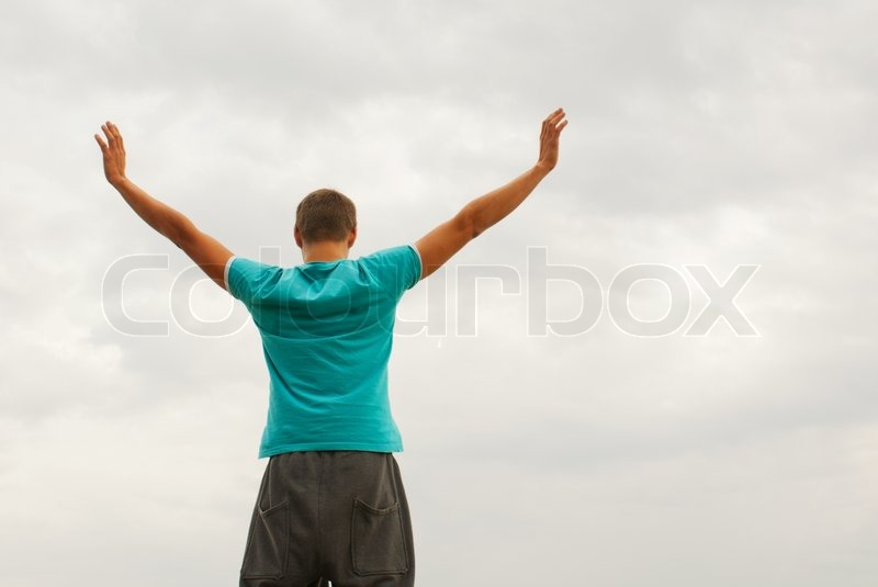 Young man staying with raised hands ... | Stock image | Colourbox
