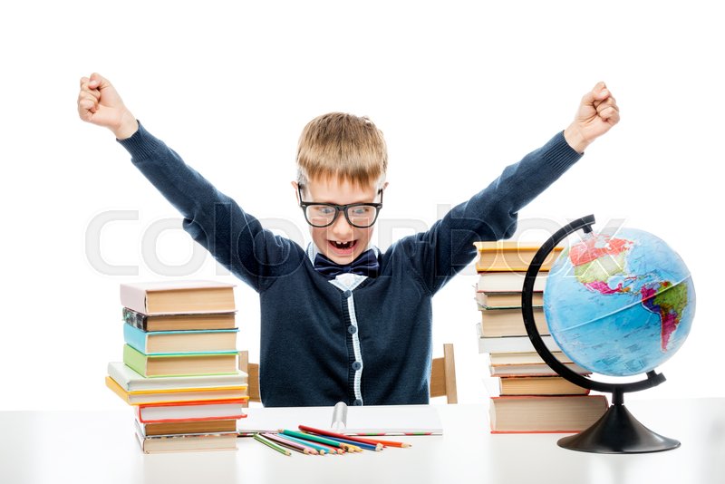 Angry boy at table with books and globe ... | Stock image | Colourbox
