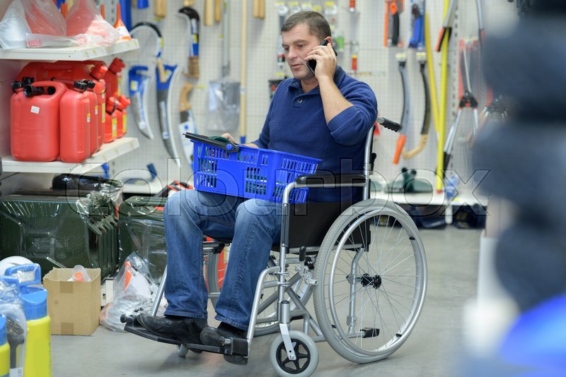 Disabled worker buying tools in a store | Stock image | Colourbox