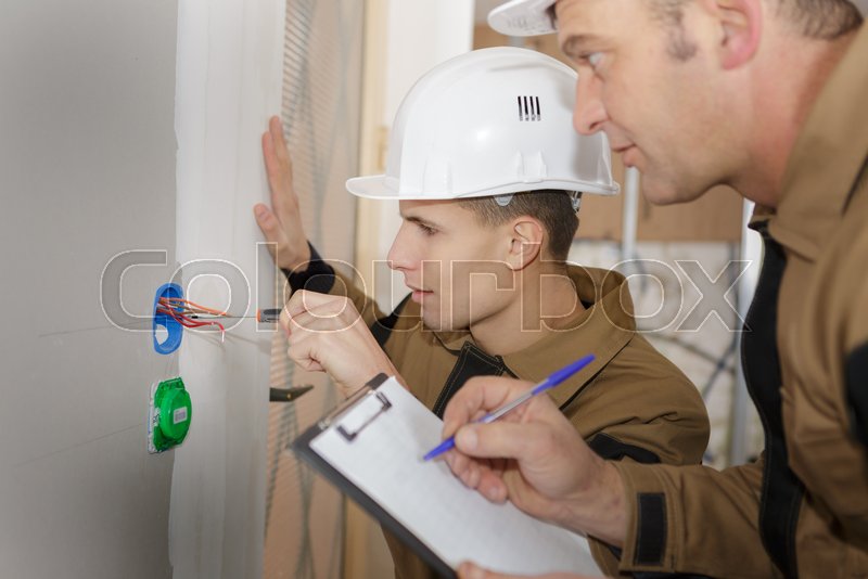 Two electrician workers at wiring cable ... | Stock image | Colourbox