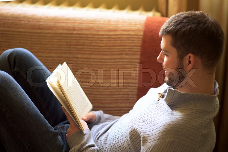 Handsome young teenage man reading his ... | Stock image | Colourbox
