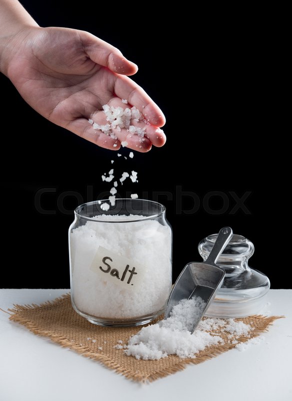 Hand sprinkling salt into glass jar ... | Stock image | Colourbox