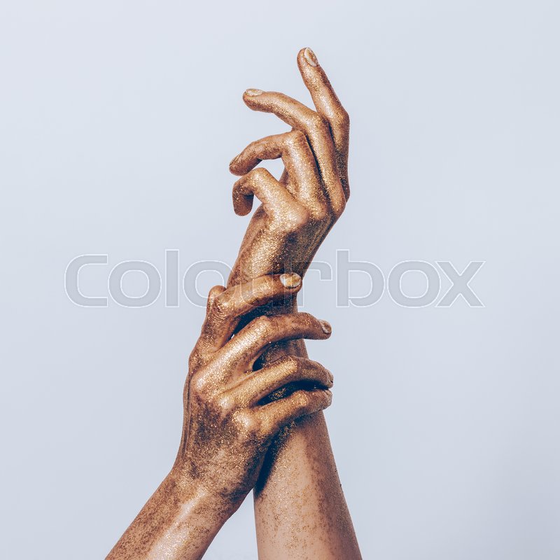 Golden female hands posing against a ... | Stock image | Colourbox